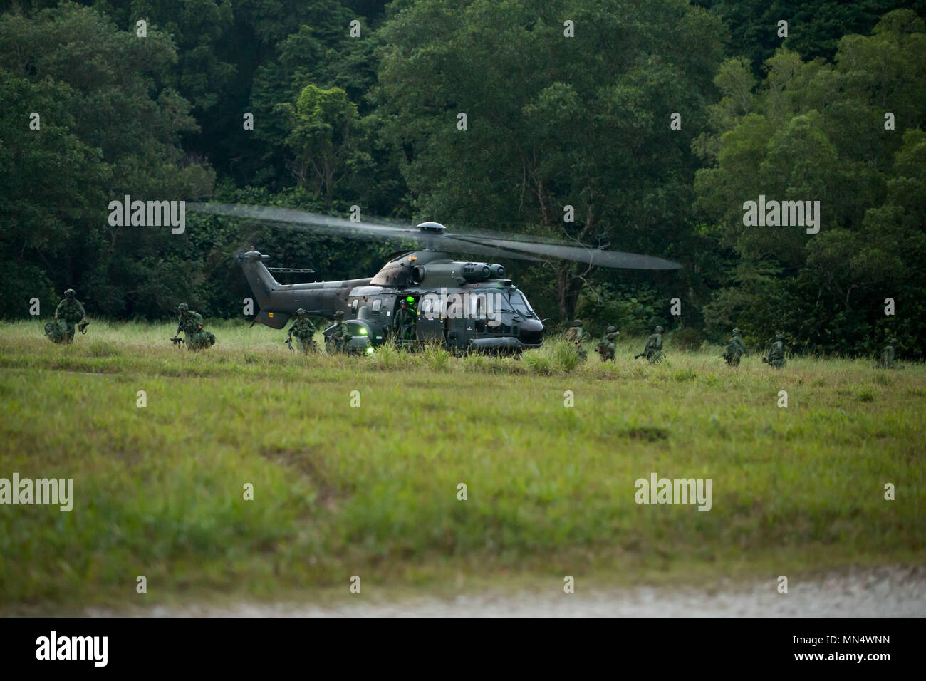 A Singapore AS-332 Super Puma inserts Singapore Armed Forces Soldiers ...