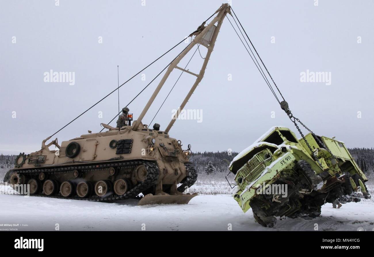 An M88 Armored Recovery Vehicle lifts a truck on snow. Snow and ice can ...