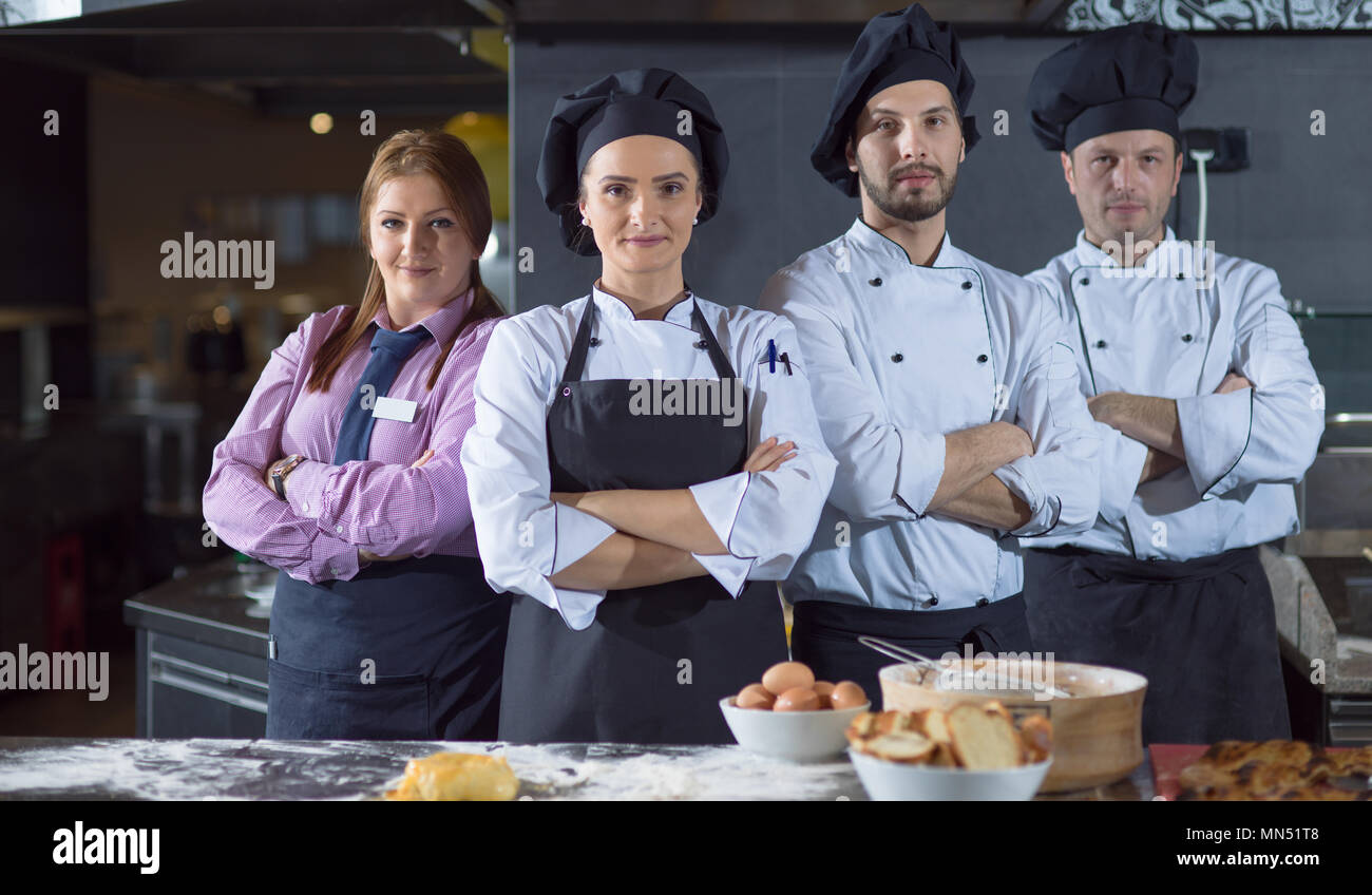 Portrait of group chefs standing together in commercial kitchen at ...