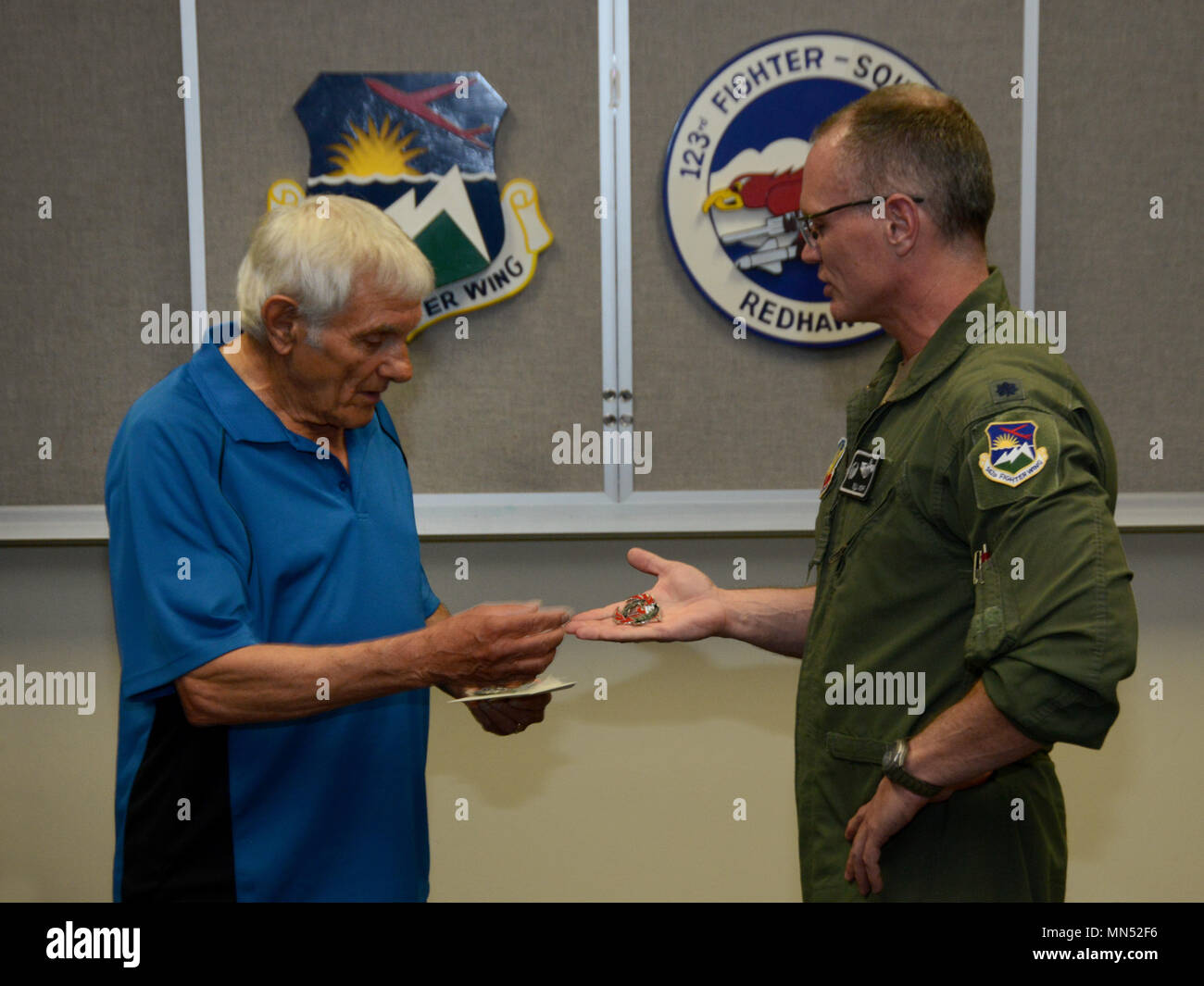 George Smolcic (left) is given a 123rd Fighter Squadron unit coin by Lt ...