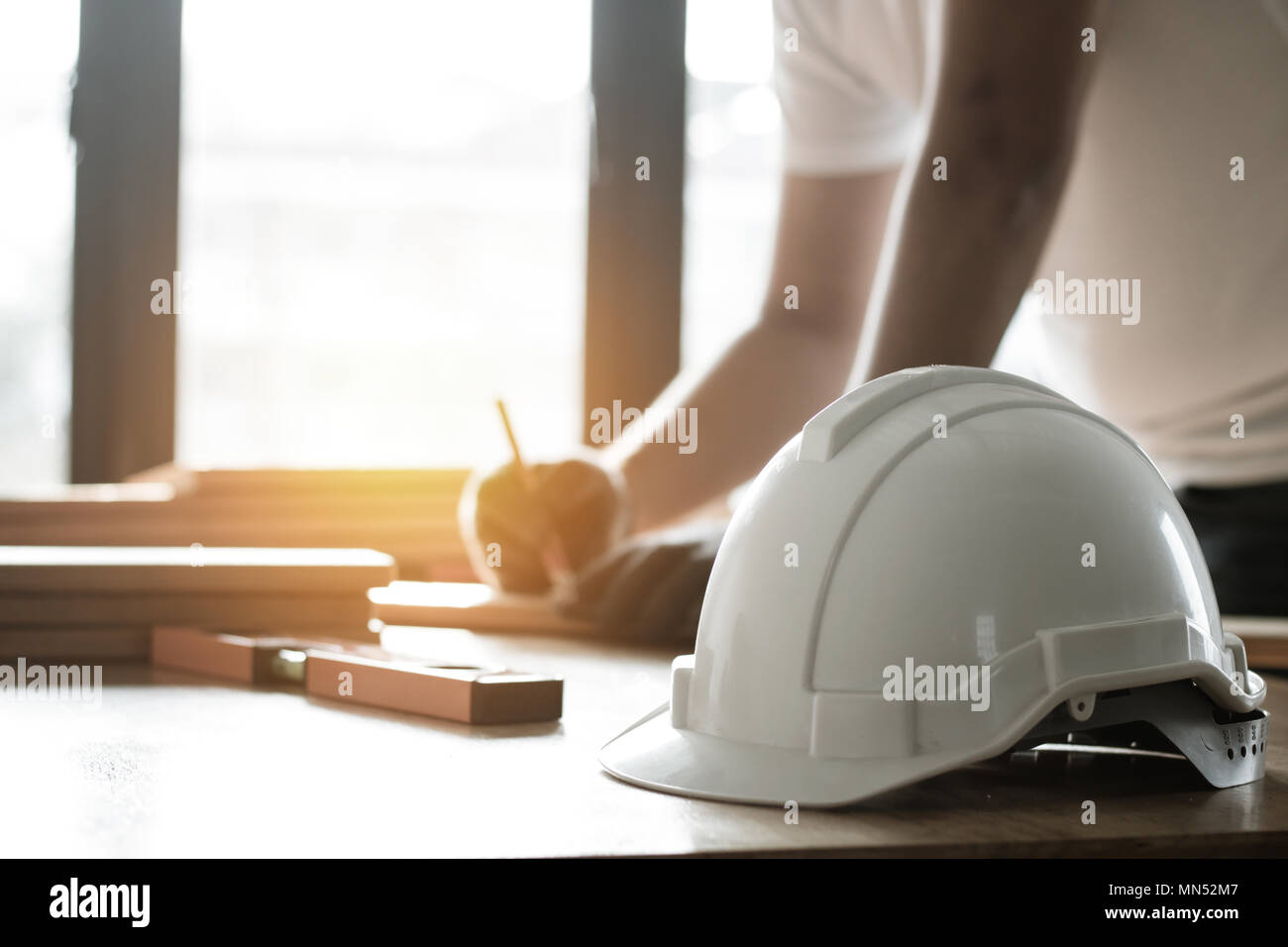 carpenter measuring and writing on wood with copy space background ...