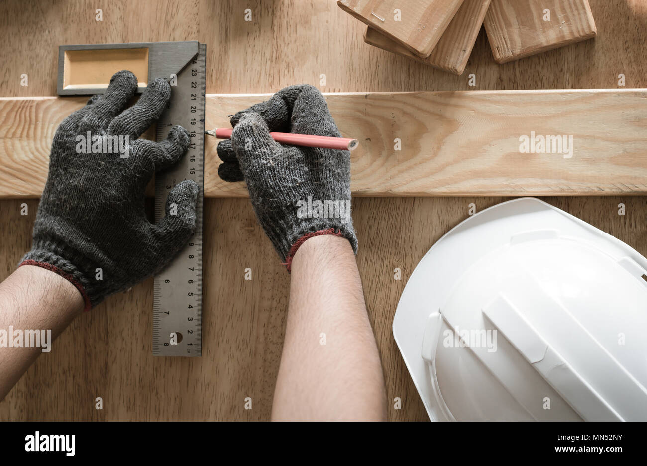 top view of carpenter measuring and writing on wood with copy space ...