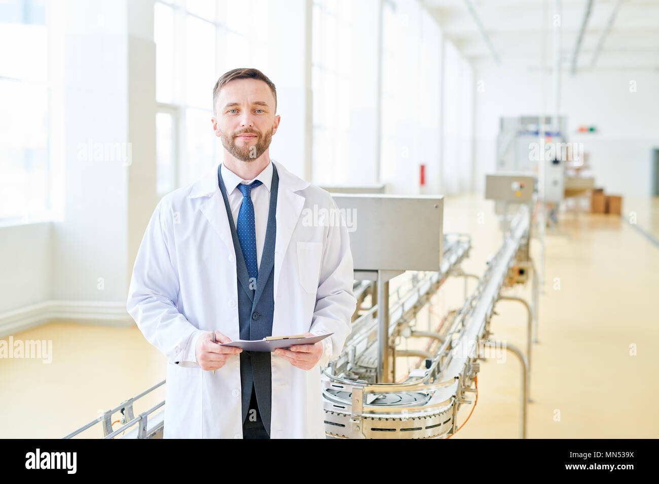 Portrait shot of handsome bearded inspector wearing suit and white coat ...