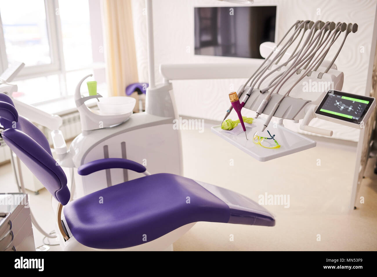 Background image of empty dentists office with purple dental chair ...