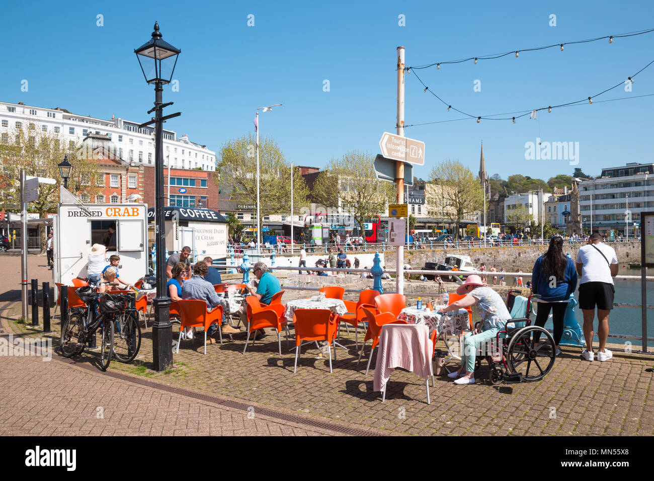 tourists sitting in an outside cafe, Torquay harbour, Devon UK Stock ...