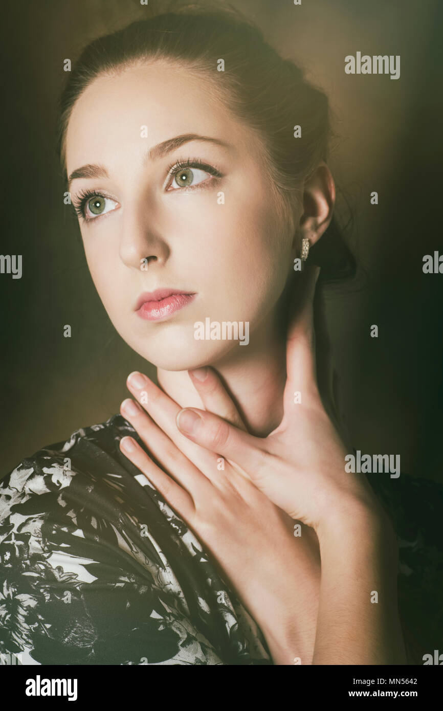 Beautiful woman hands touching neck looking away Stock Photo - Alamy