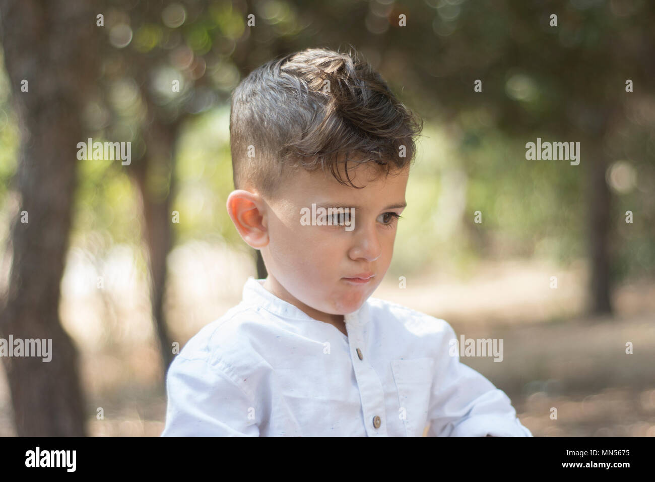 Little boy looking away in the park Stock Photo - Alamy