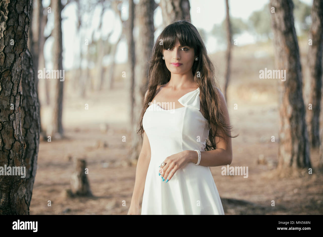 Beautiful woman standing in the forest Stock Photo - Alamy