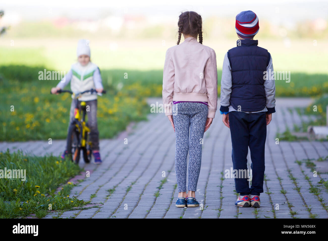 Full length back view of two children, girl with braids and boy in ...