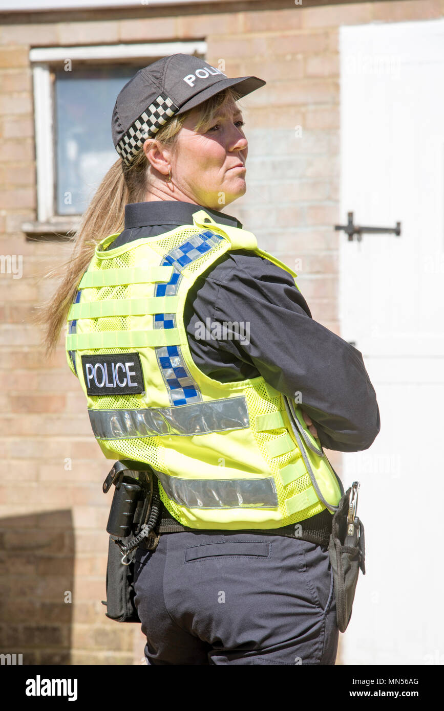 Rear and side portrait view of a woman police officer wearing a cap ...