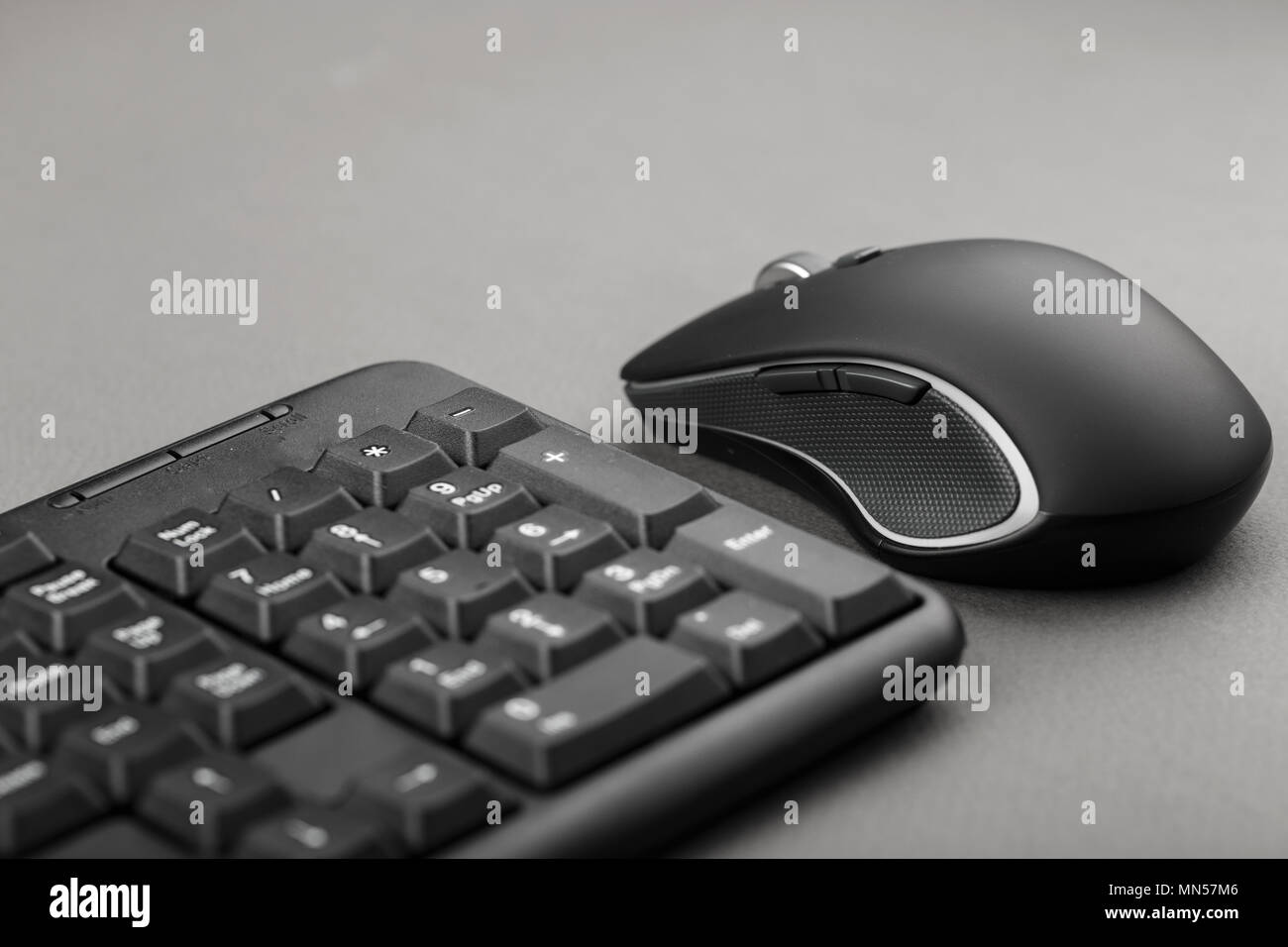 black computer mouse near the keyboard, office equipment on the table ...