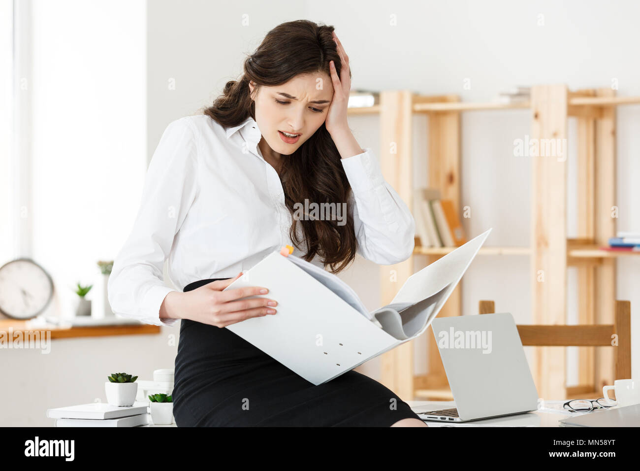 Worried businesswoman reading a notification report while is working ...