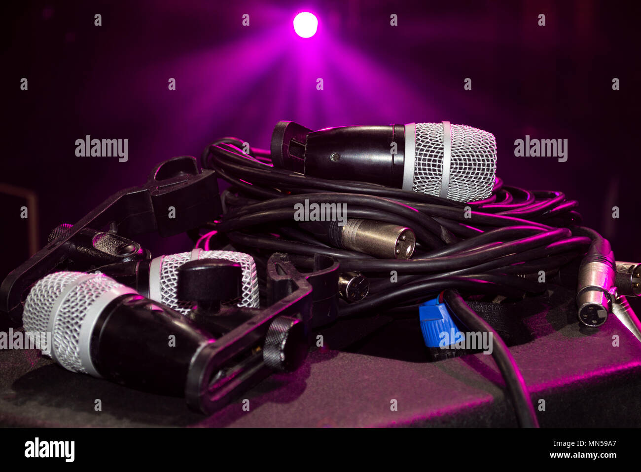 Microphone and cable lying on the stage before the show in magenta ...