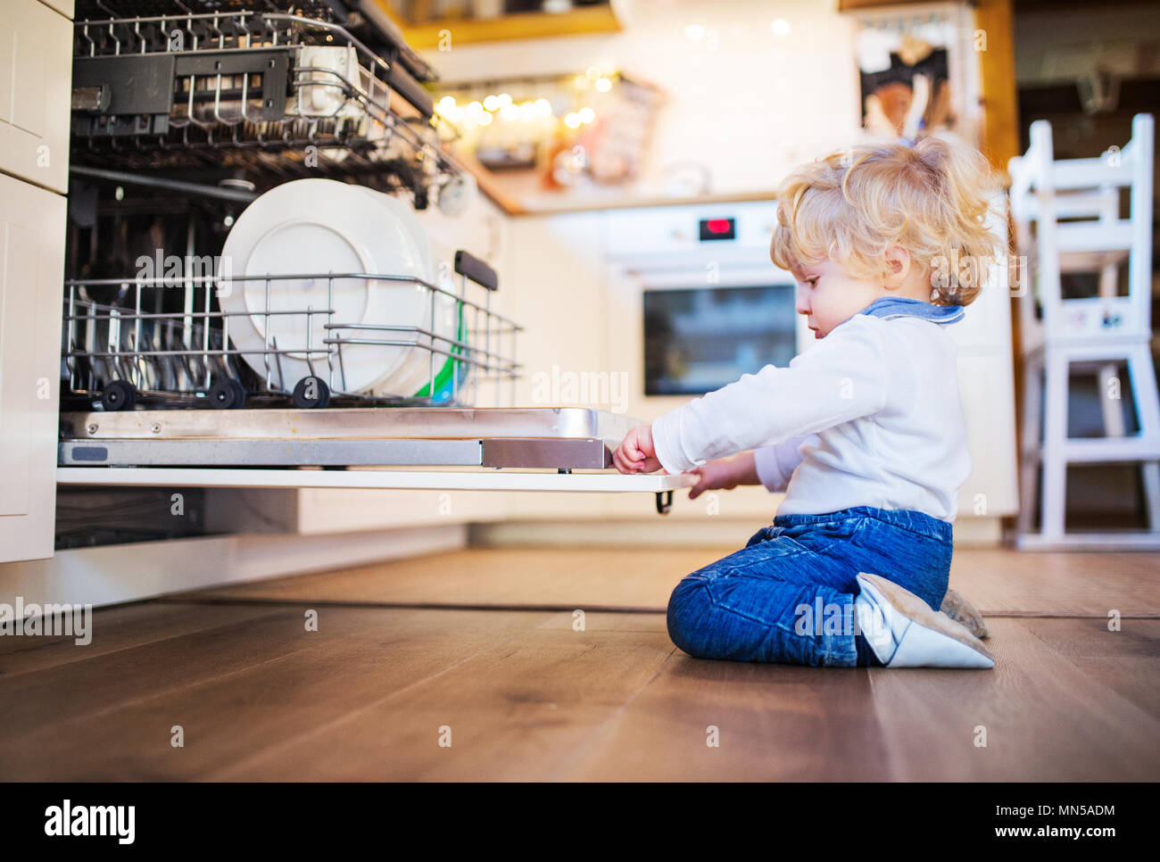Little toddler boy in a dangerous situation at home. Domestic accident ...