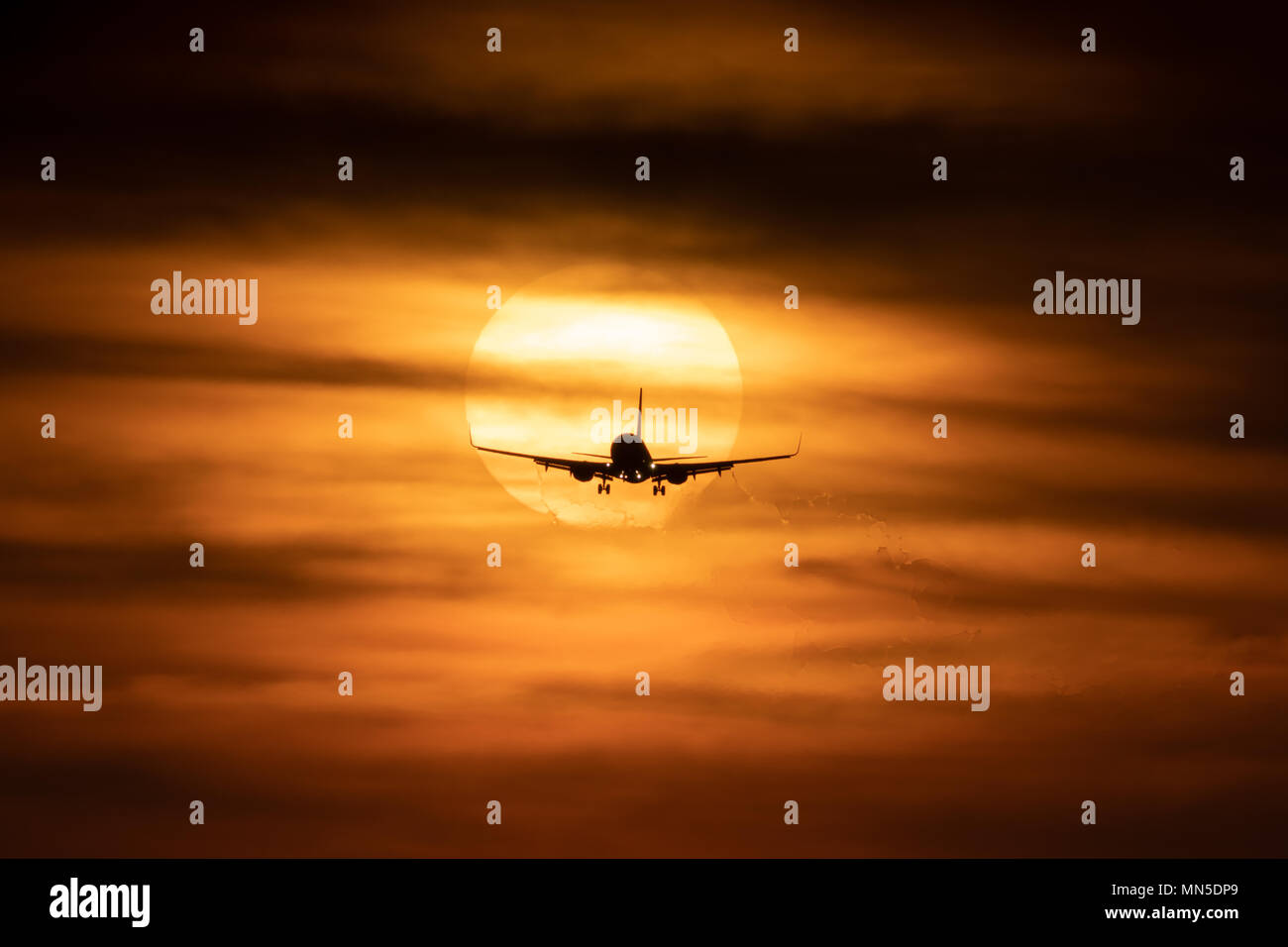 Beautiful sunset with sun behind airplane Stock Photo - Alamy