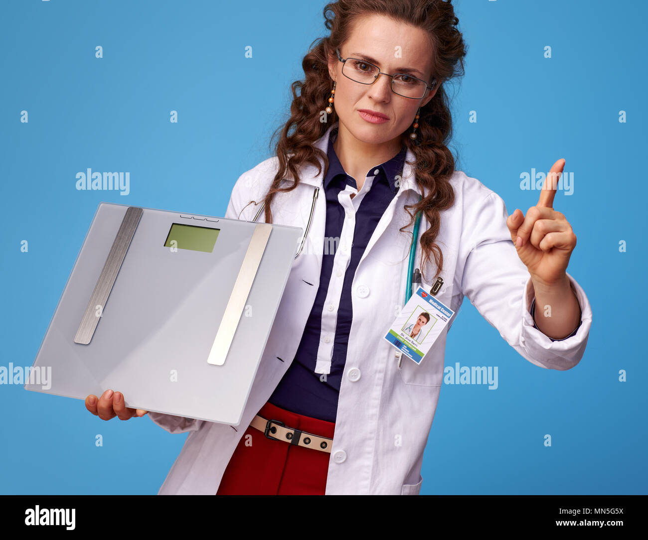 medical practitioner woman in white medical robe with scales and rised ...