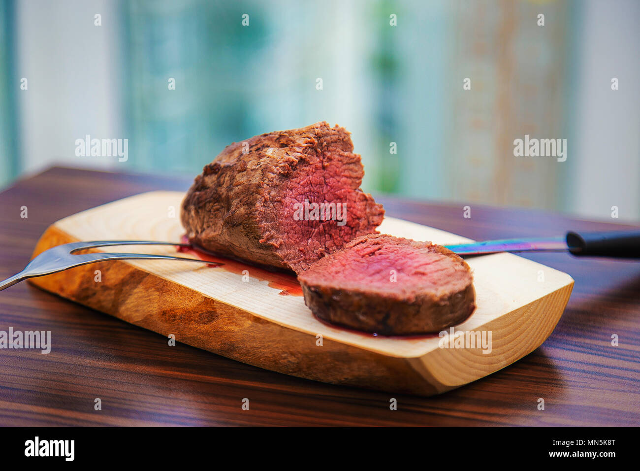 Rare underdone sliced rib beef ober wooden plate Stock Photo - Alamy