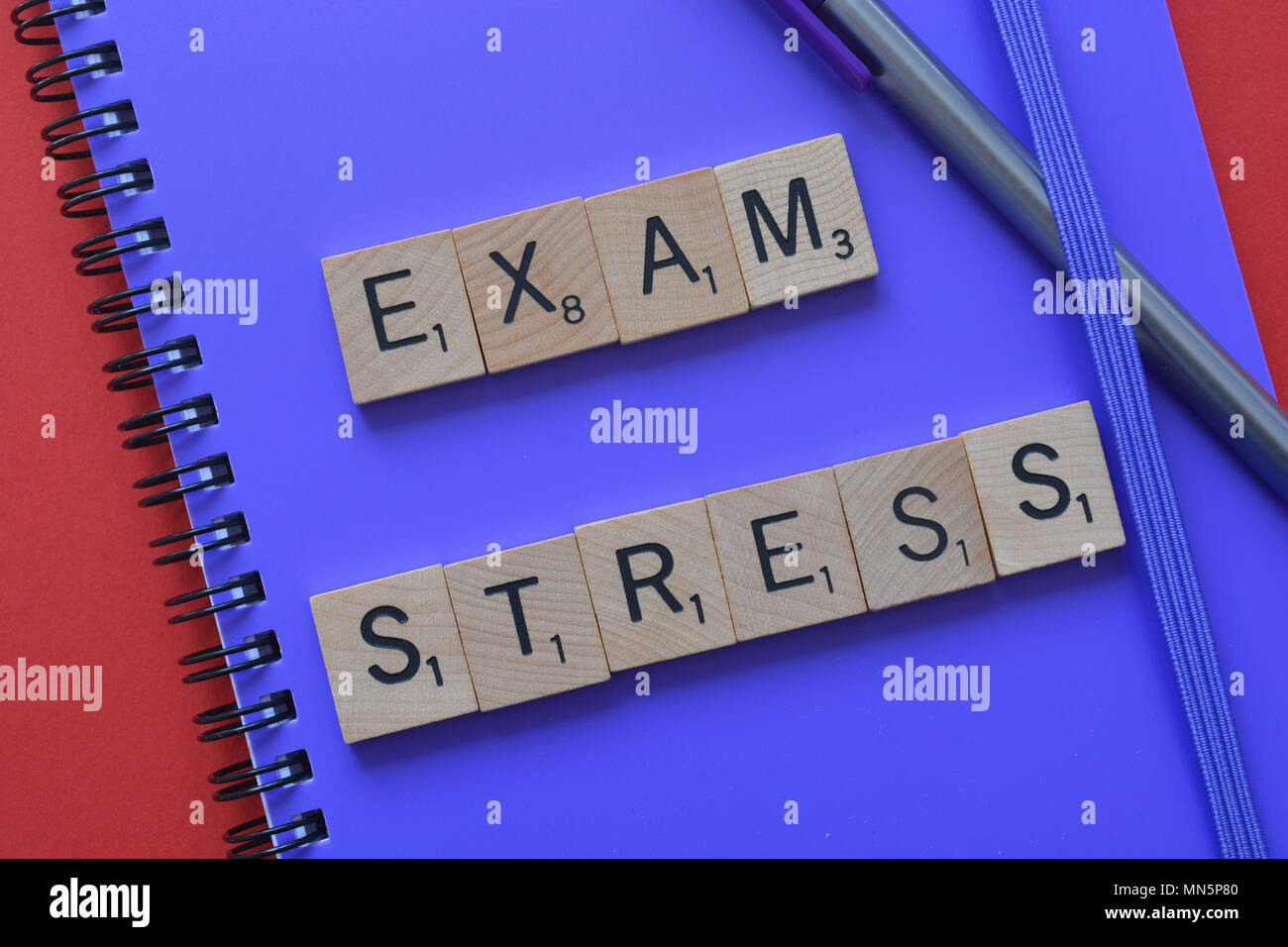 The words Exam Stress in wooden letters on a spiral bound notebook ...