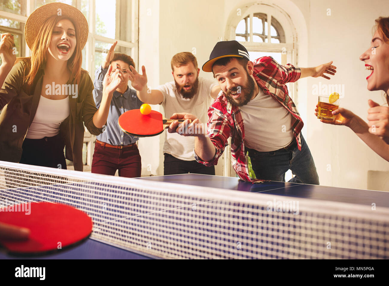 Group of happy young friends playing ping pong table tennis Stock Photo ...