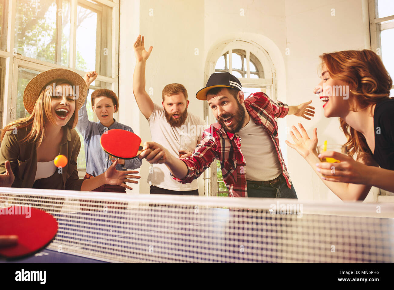 Group of happy young friends playing ping pong table tennis Stock Photo ...