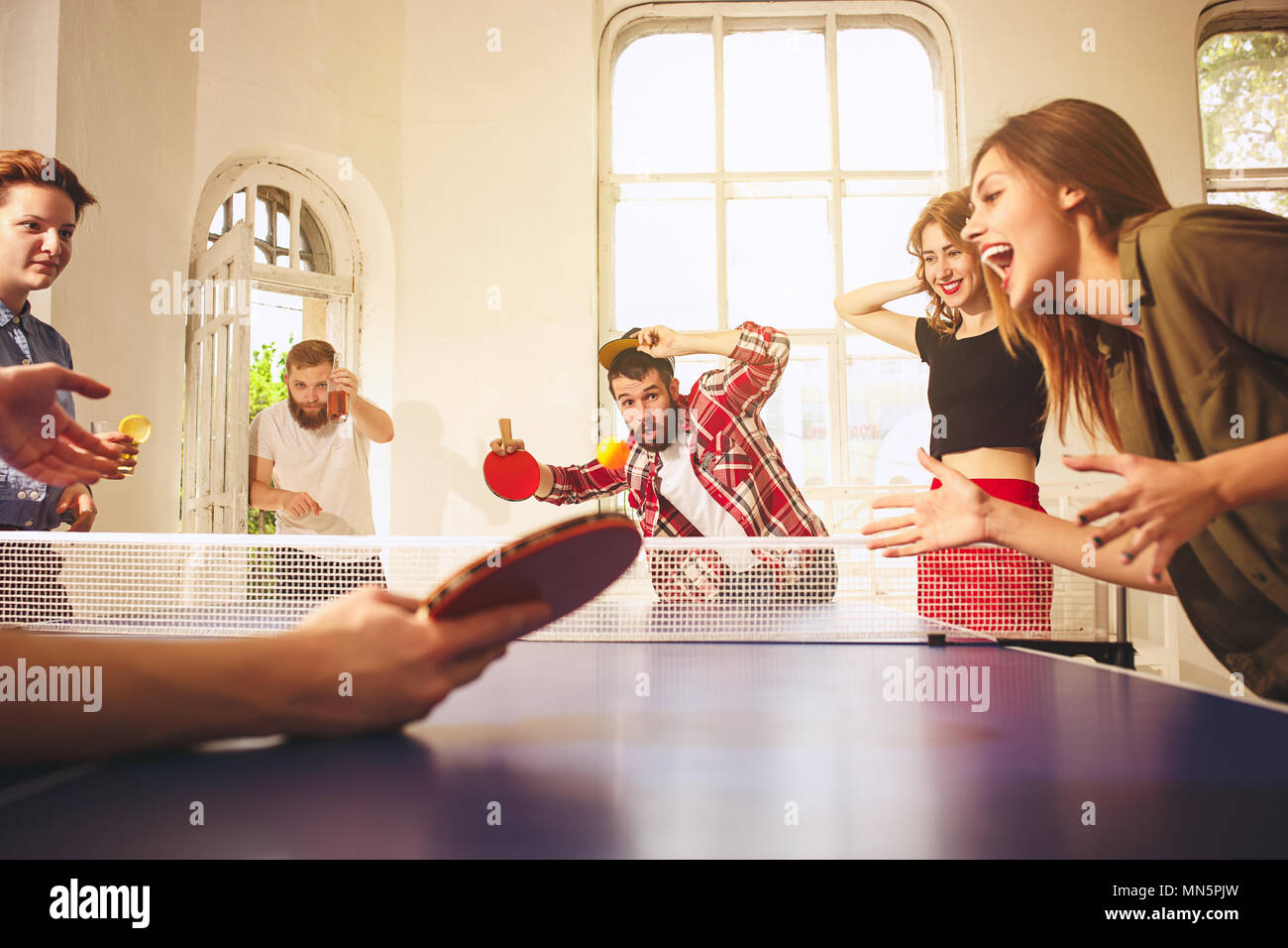 Group of happy young friends playing ping pong table tennis Stock Photo ...