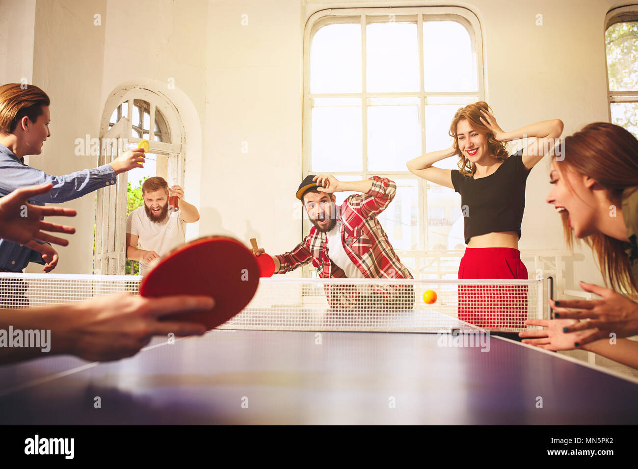 Group of happy young friends playing ping pong table tennis Stock Photo ...