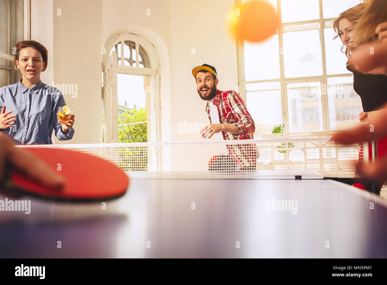 Group of happy young friends playing ping pong table tennis Stock Photo ...