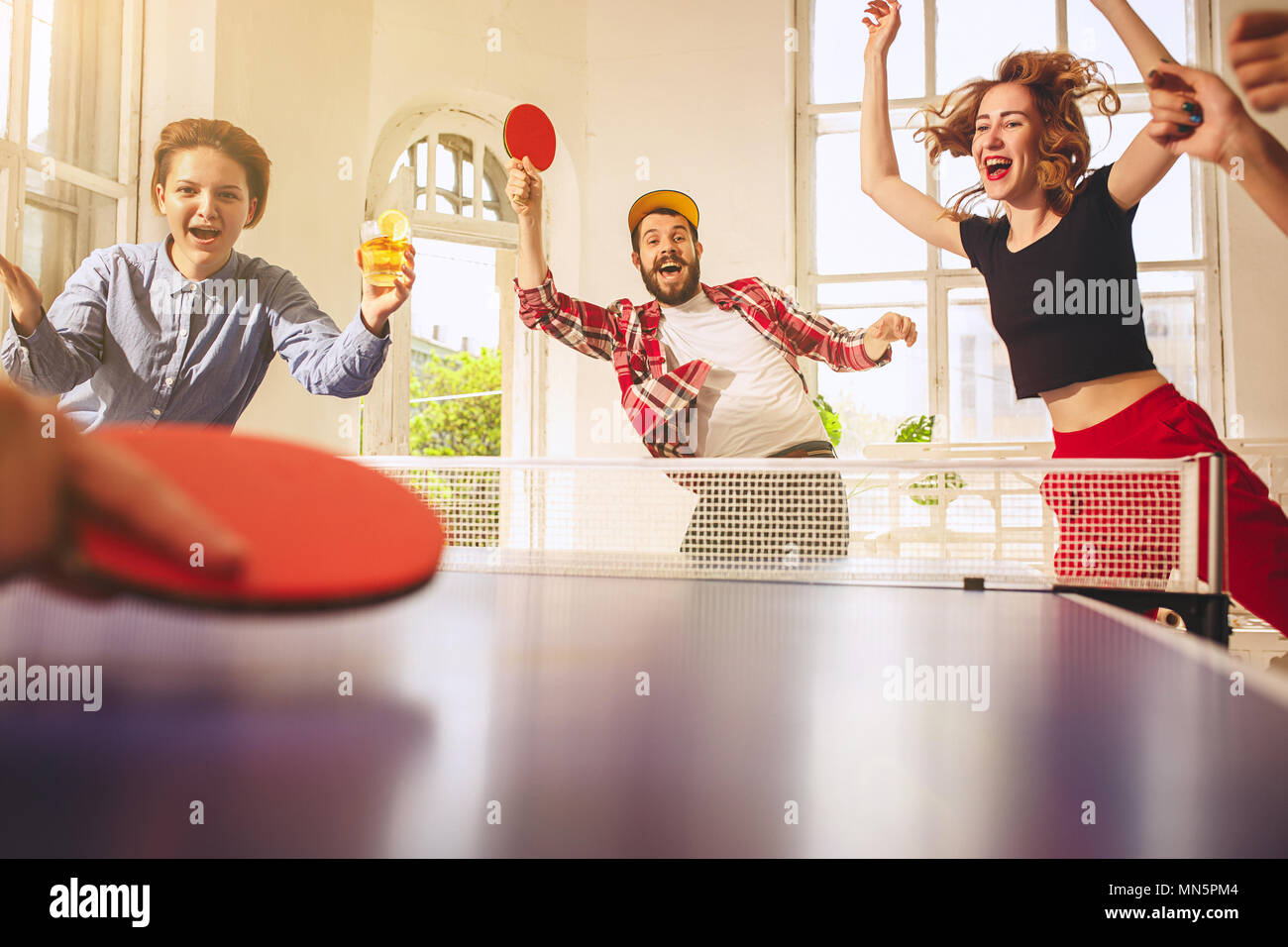 Group of happy young friends playing ping pong table tennis Stock Photo ...