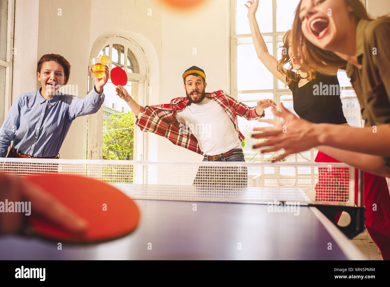 Group of happy young friends playing ping pong table tennis Stock Photo ...