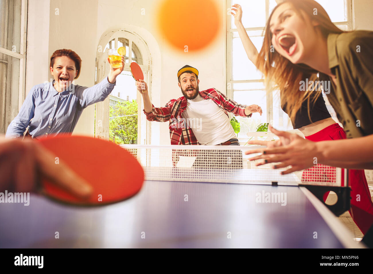 Group of happy young friends playing ping pong table tennis Stock Photo ...