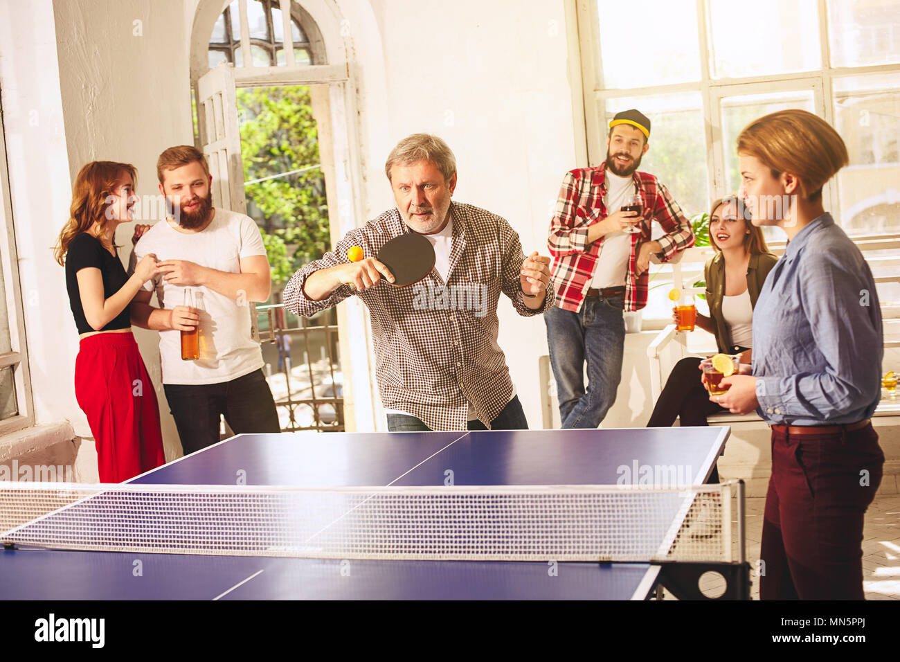 Group of happy young friends playing ping pong table tennis Stock Photo ...