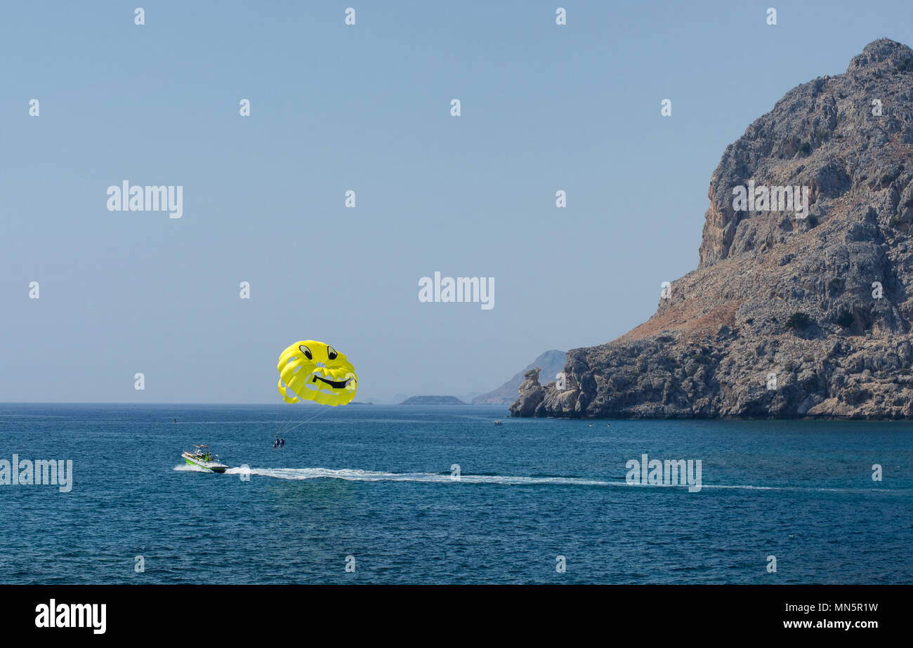 Mediterranean seascape with tourists engaged in parasailing. Parachute ...