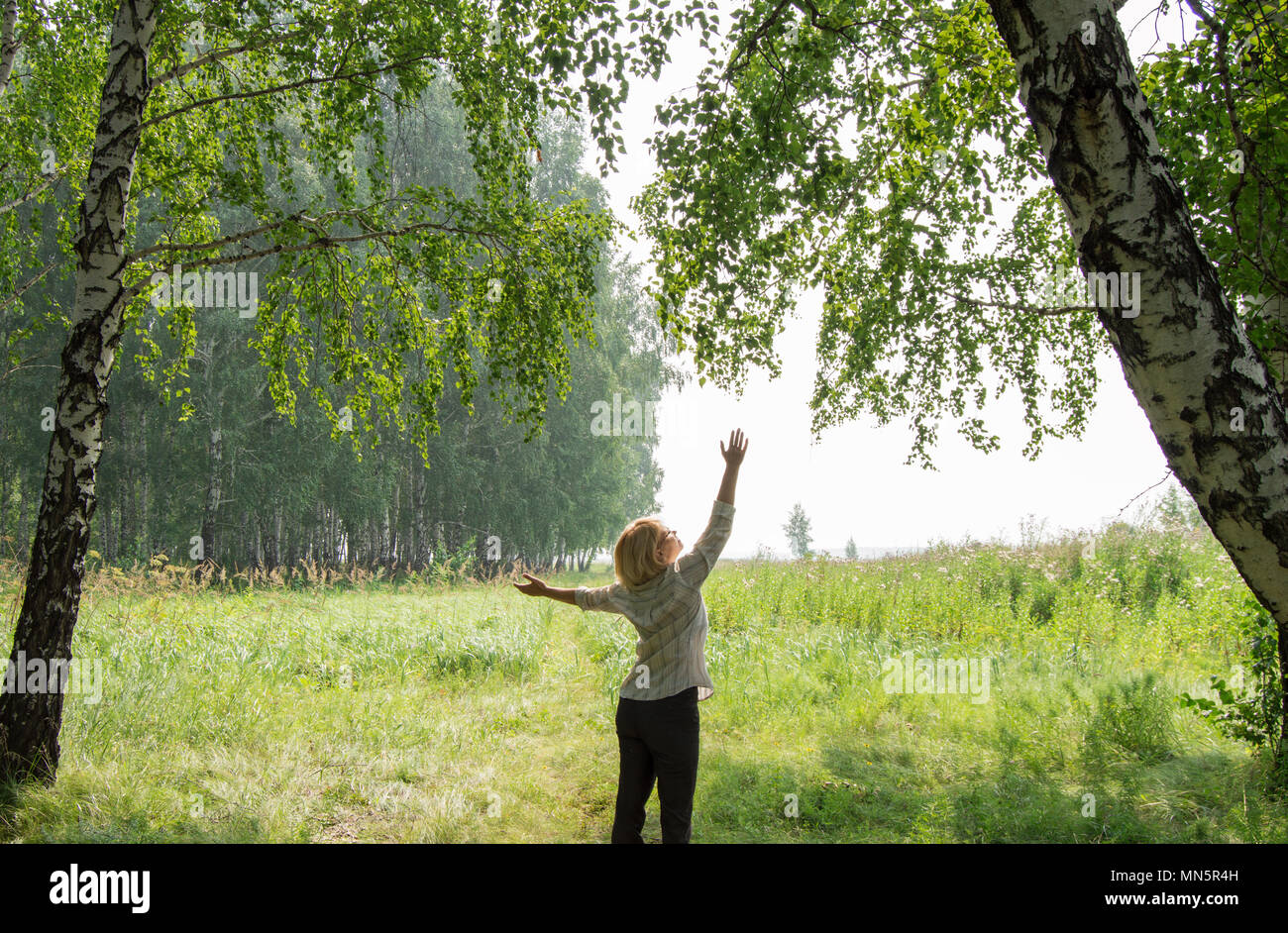 Woman near trees raised their hands. The concept of ecology and nature ...