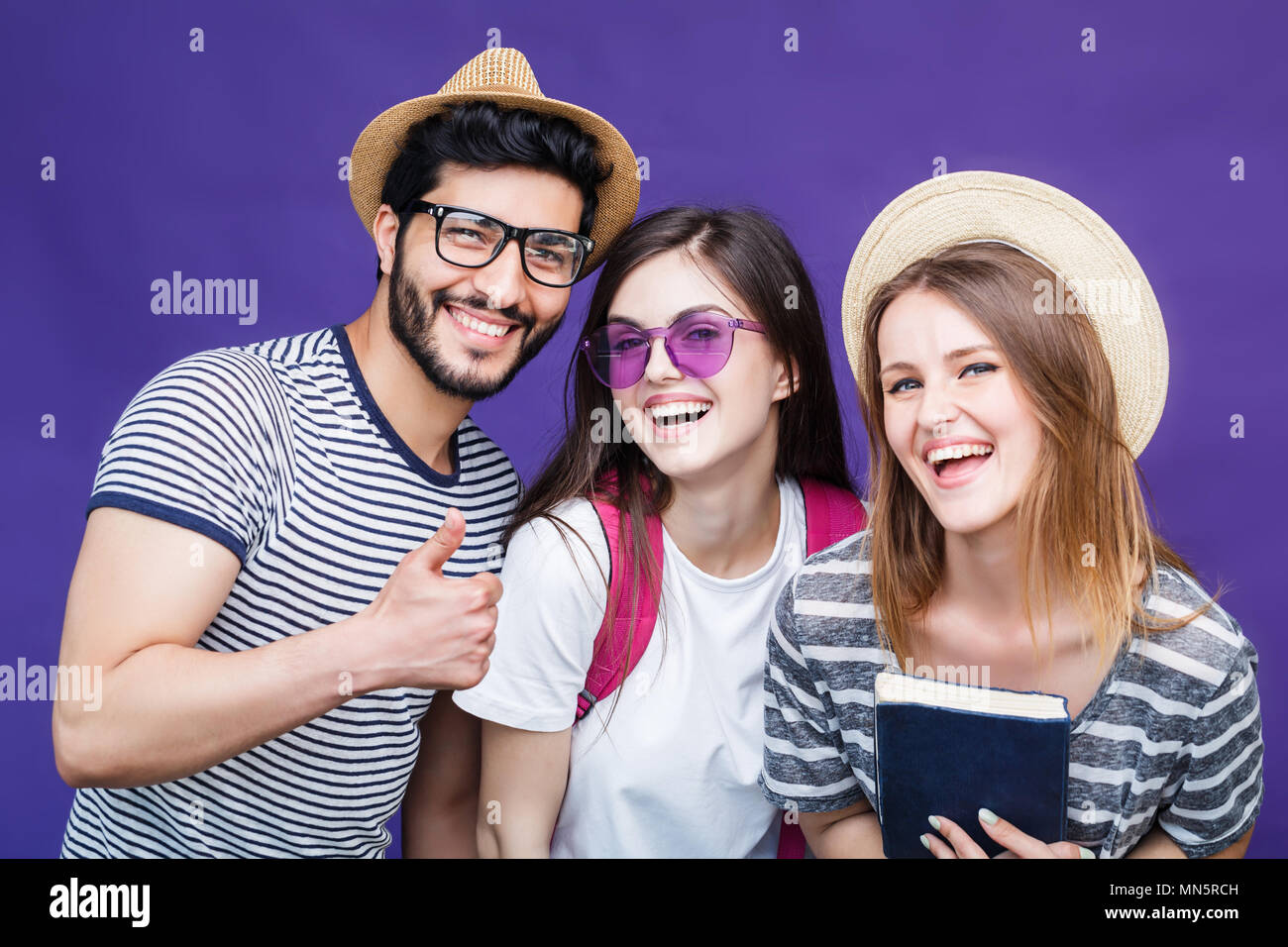 Happy smiling students dressed in t-shirts and hats and eyeglasses ...