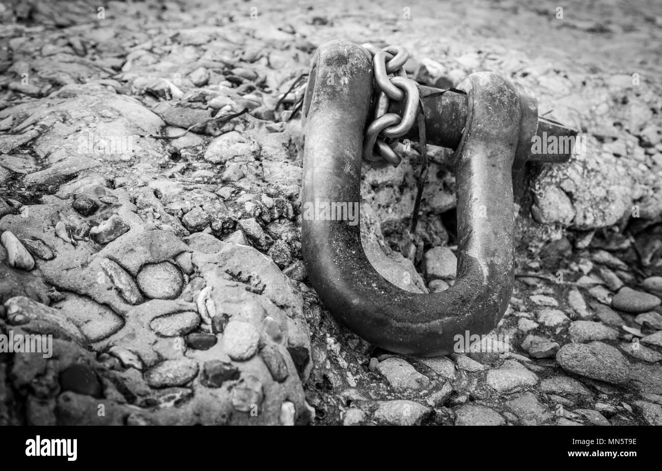 Shackle with chain link in stone Stock Photo - Alamy