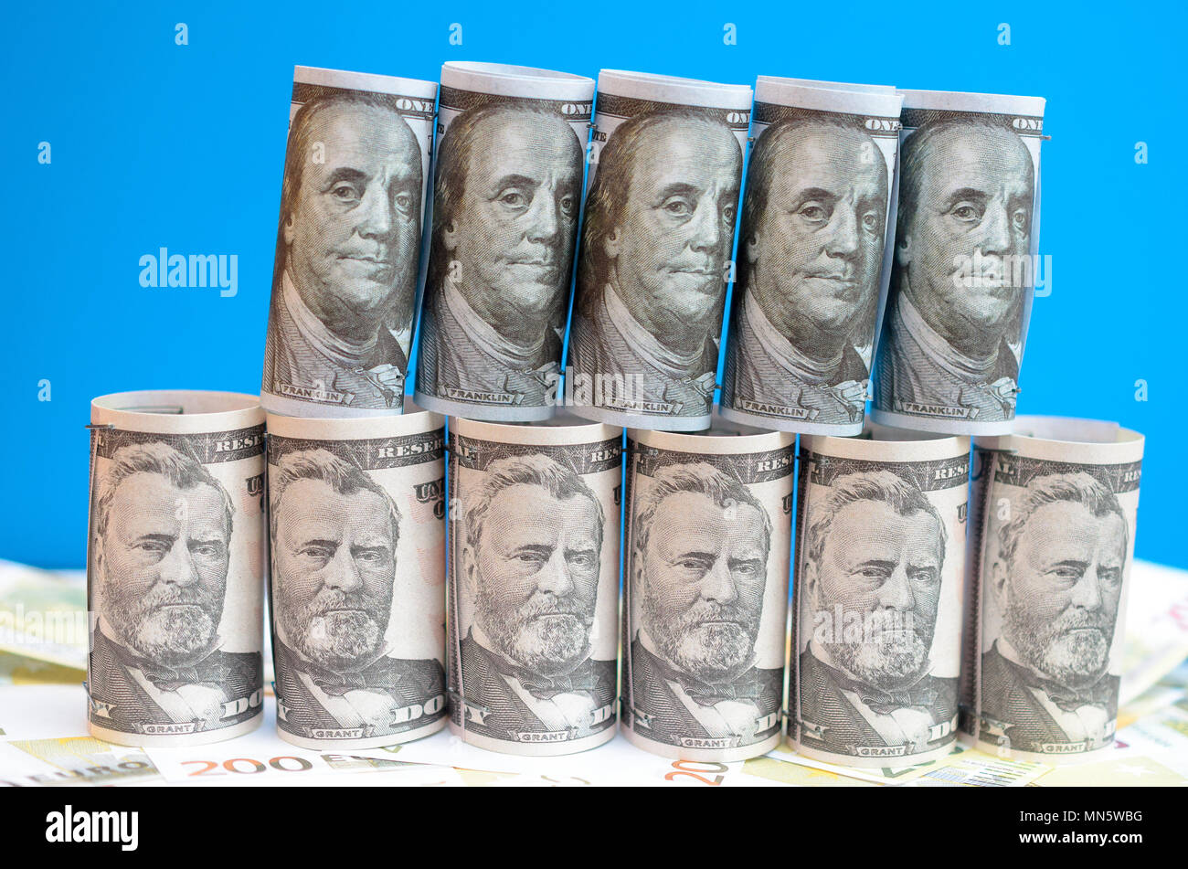 A lot of twisted dollar bills on a blue background Stock Photo - Alamy