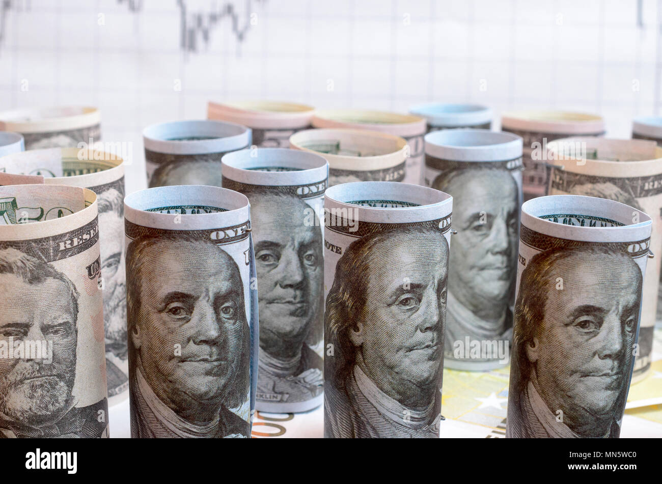 A lot of twisted dollar bills on the background of financial charts ...
