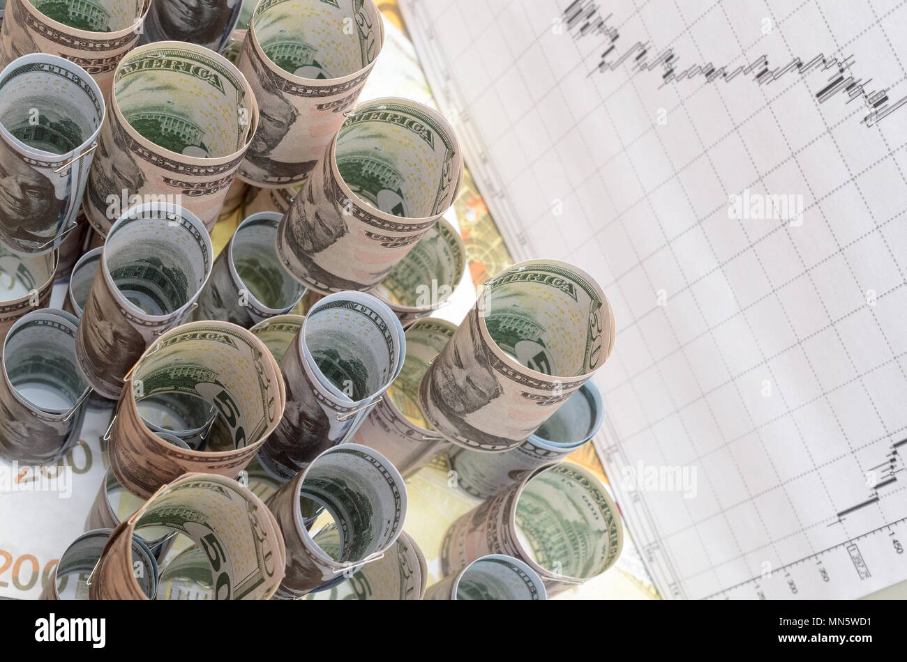 A lot of twisted dollar bills on the background of financial charts ...