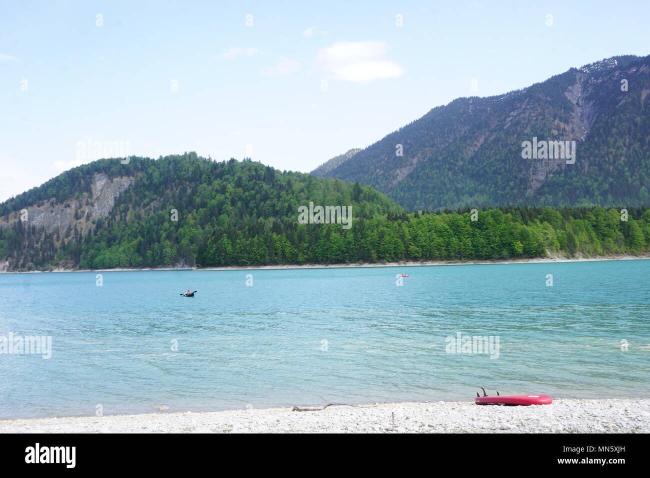 Very blue lake in the mountains of Bavaria in Germany with forrest ...
