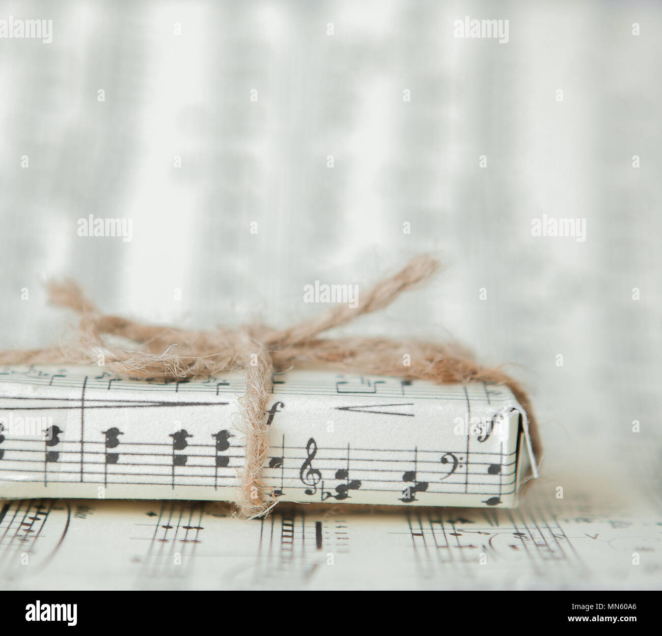 Giftbox on music sheet. A musical gift on notes background Stock Photo ...