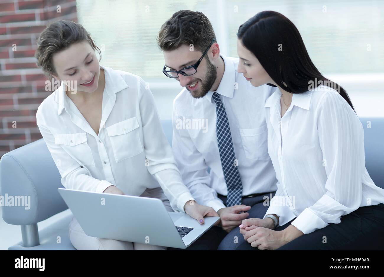 business team looks at the information on the laptop Stock Photo - Alamy
