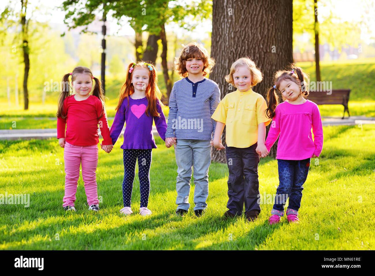 a group of small children smiling holding hands on a background of ...