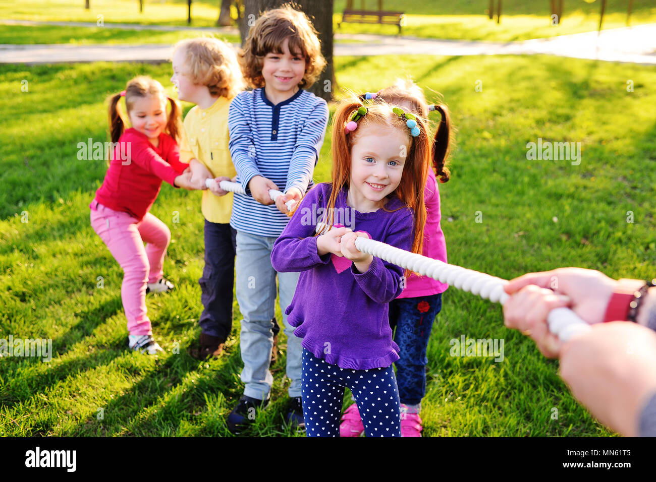 Children play tug of war in the park Stock Photo - Alamy