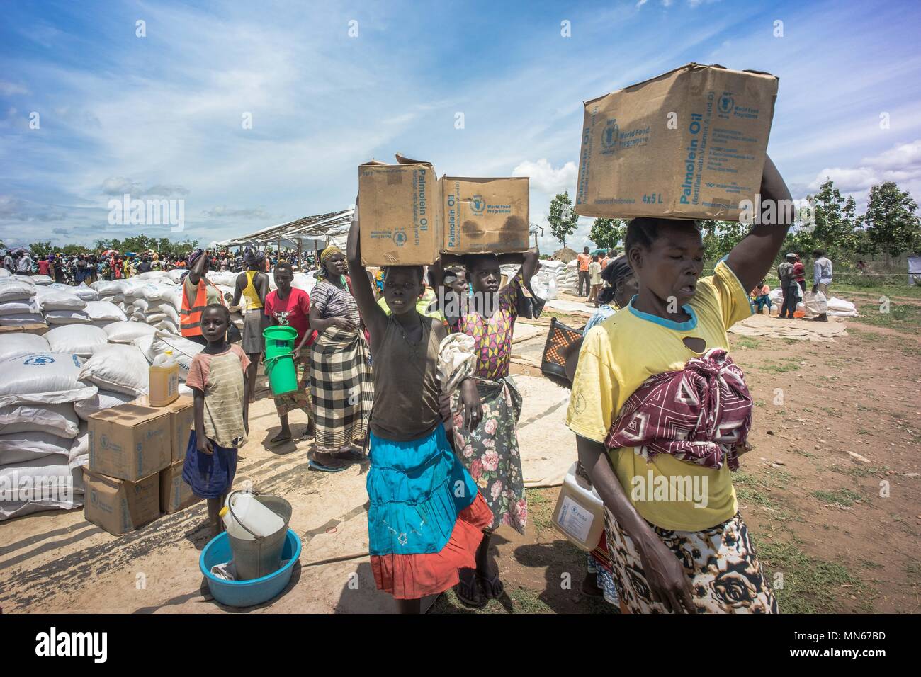 South Sudanese female refugees seen carrying palm oil on top of their heads as they were given ...
