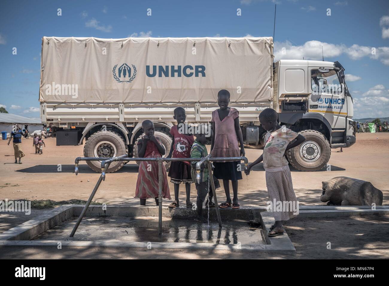 Young South Sudanese refugees seen getting water at a public water tap ...
