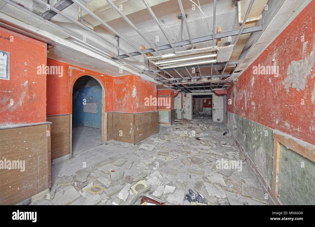 A wide corridor with a collapsed suspended ceiling inside the old ...