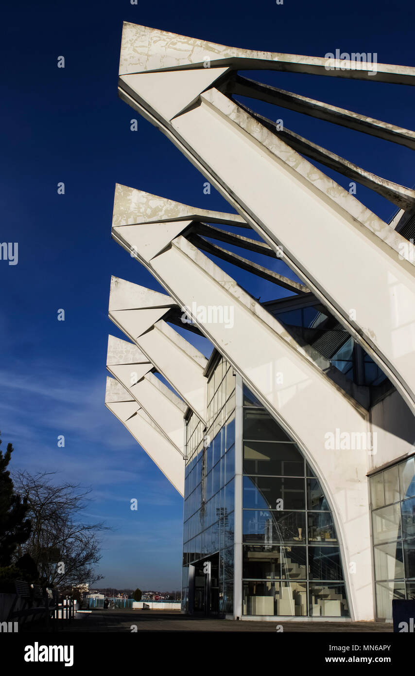 Modern high school sports building, made of glass with four white ...