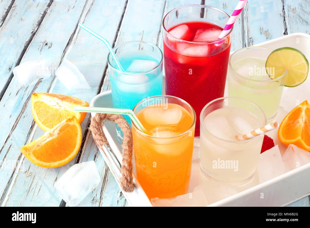 Tray of cool colorful summer drinks against a rustic wood background ...
