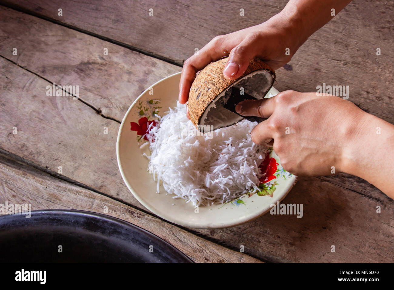Woman using hand scraping coconut put the container for make dessert ...
