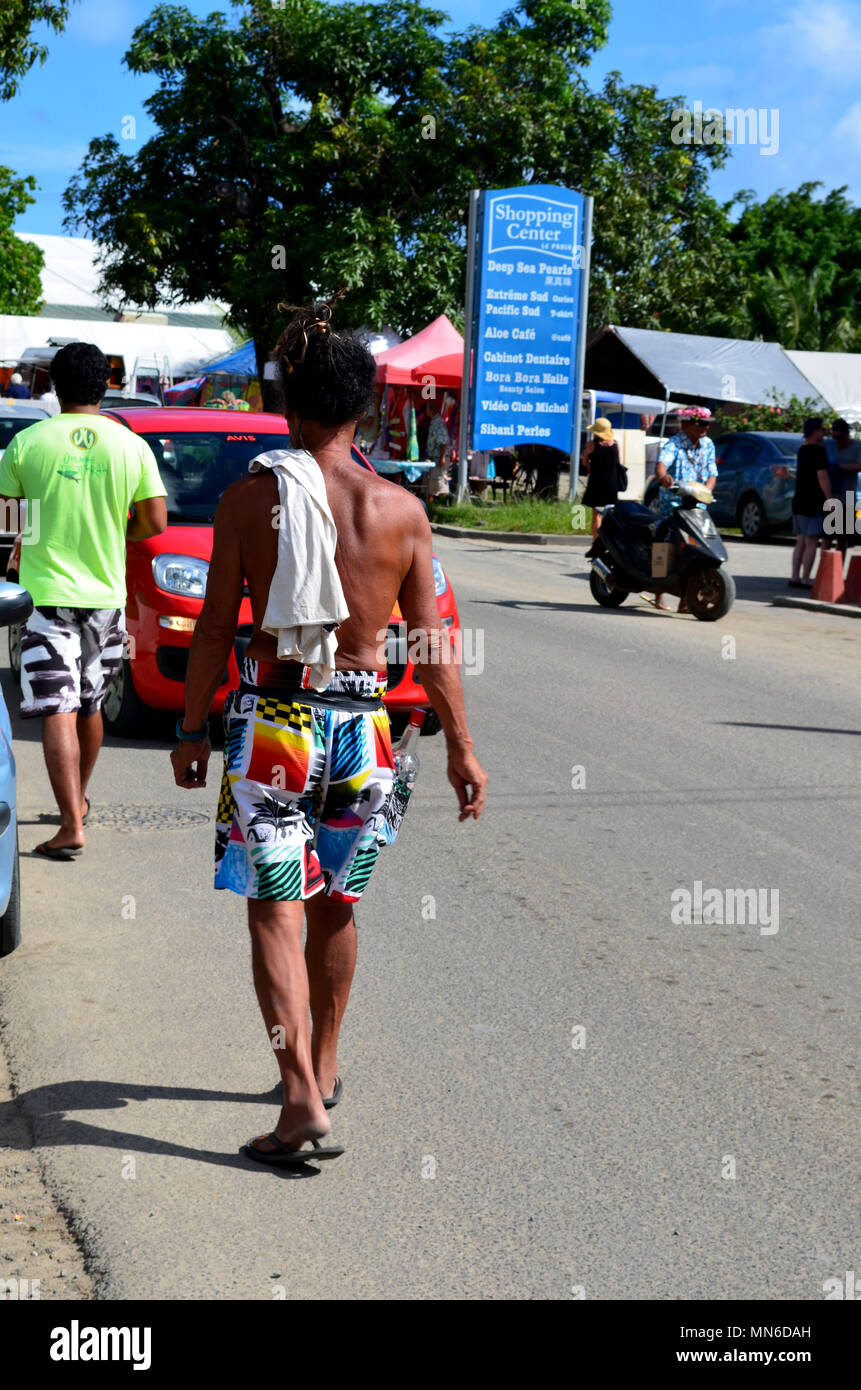 Polynesian man walking with alcohol bottle in shorts, Bora Bora French ...